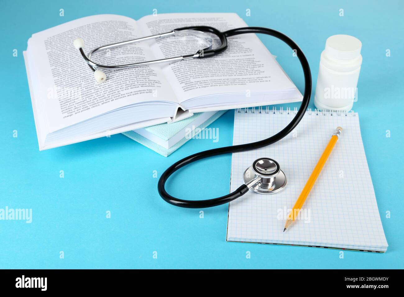 Medical stethoscope with notepad and books on blue background Stock ...