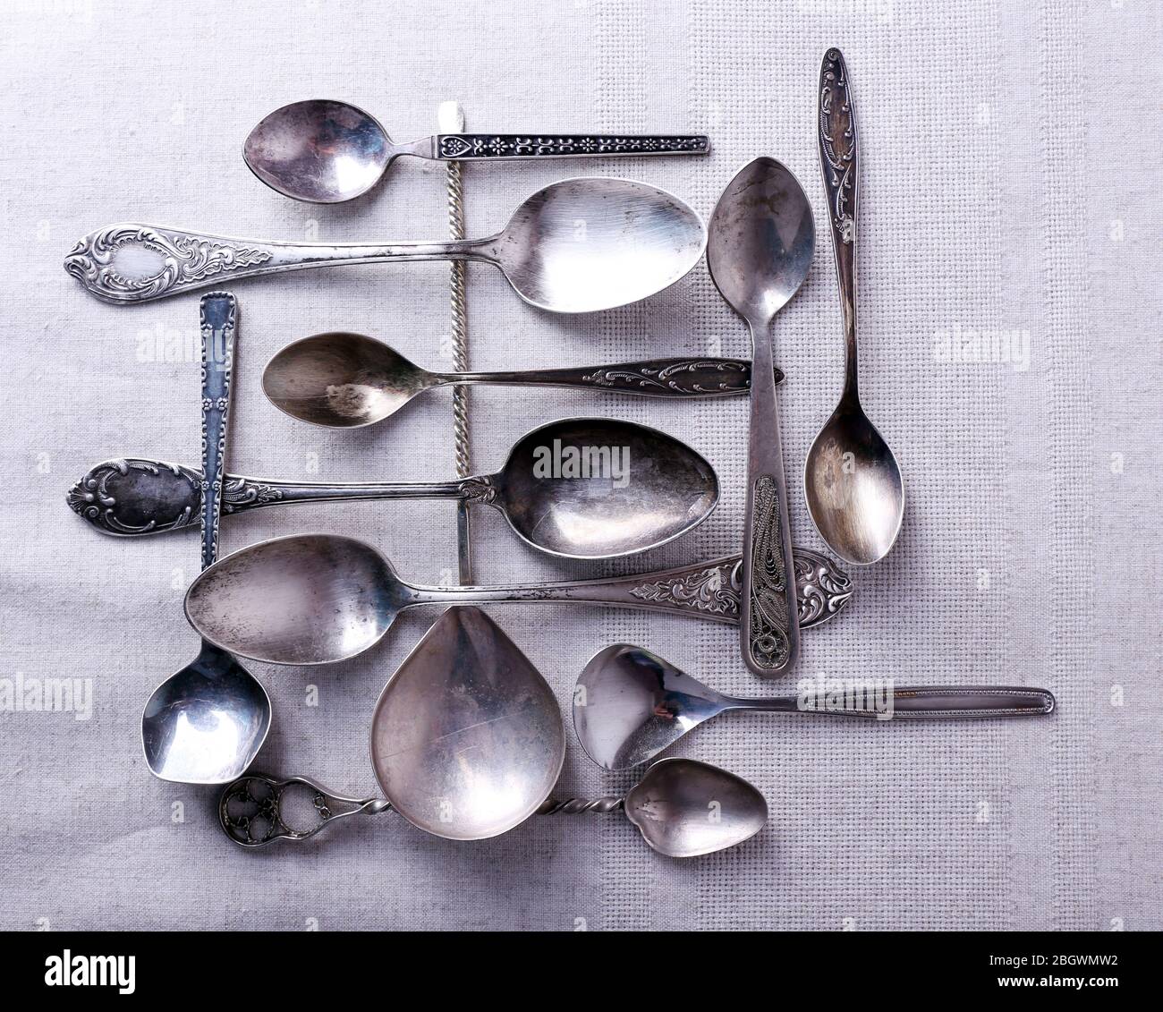 Metal spoons on fabric background Stock Photo - Alamy