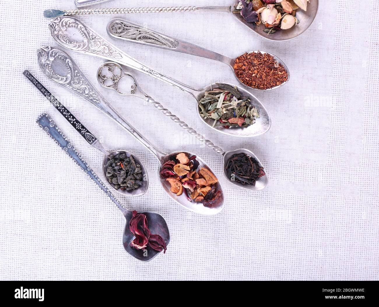 Tea in metal spoons on fabric background Stock Photo - Alamy