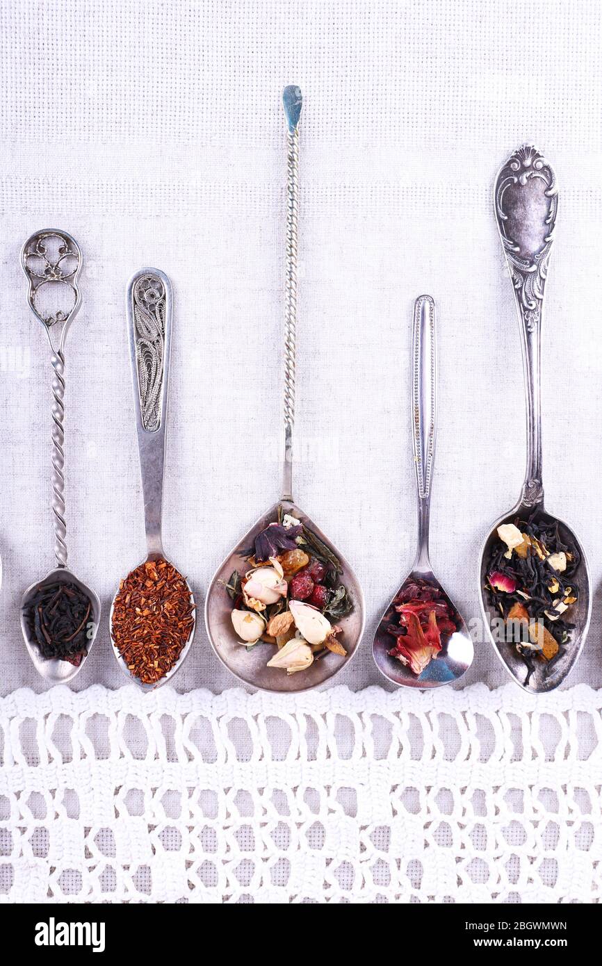 Tea in metal spoons on lace fabric background Stock Photo - Alamy