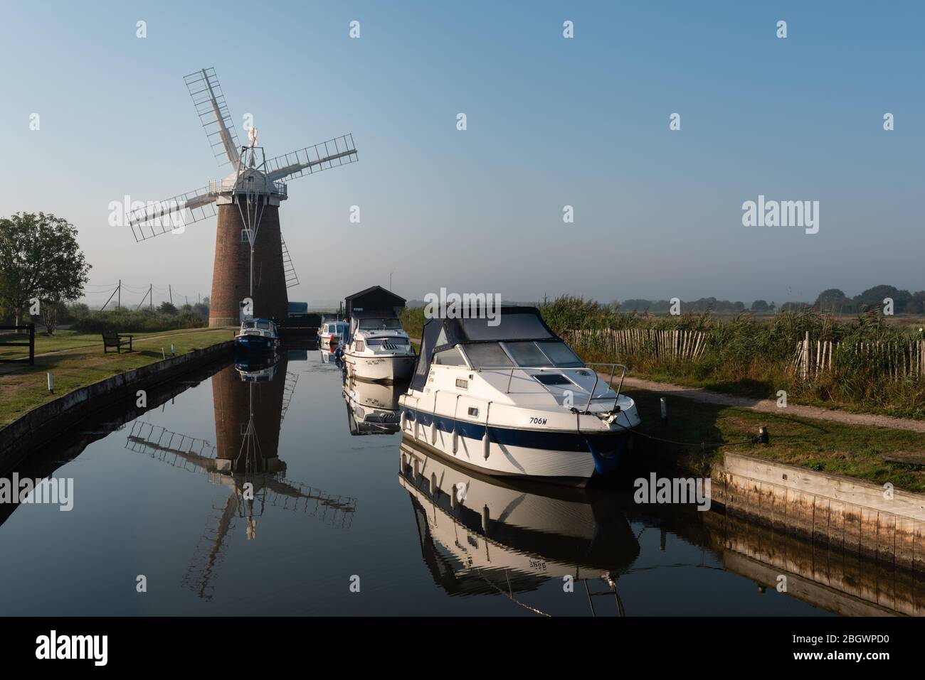 Norfolk windpump with waterway boats and reflections ii. Horsey Mill ...