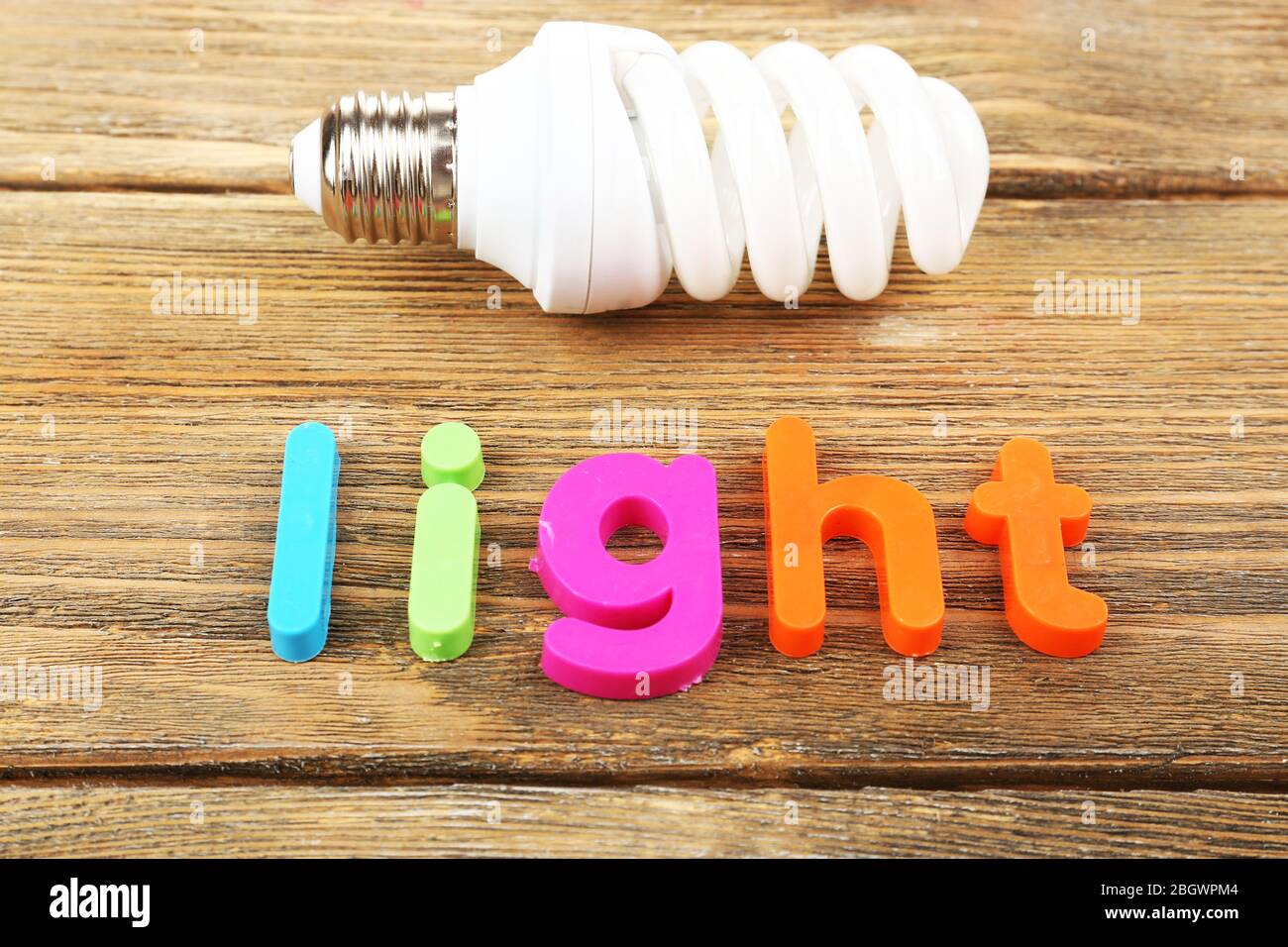 Light word formed with colorful letters on wooden background Stock ...