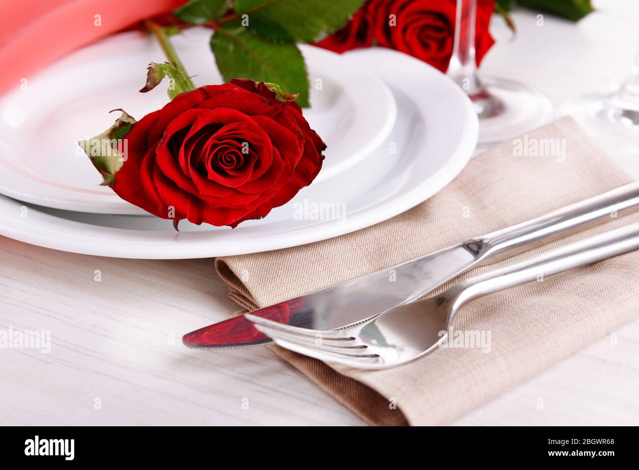 Table setting with red rose on plate Stock Photo - Alamy
