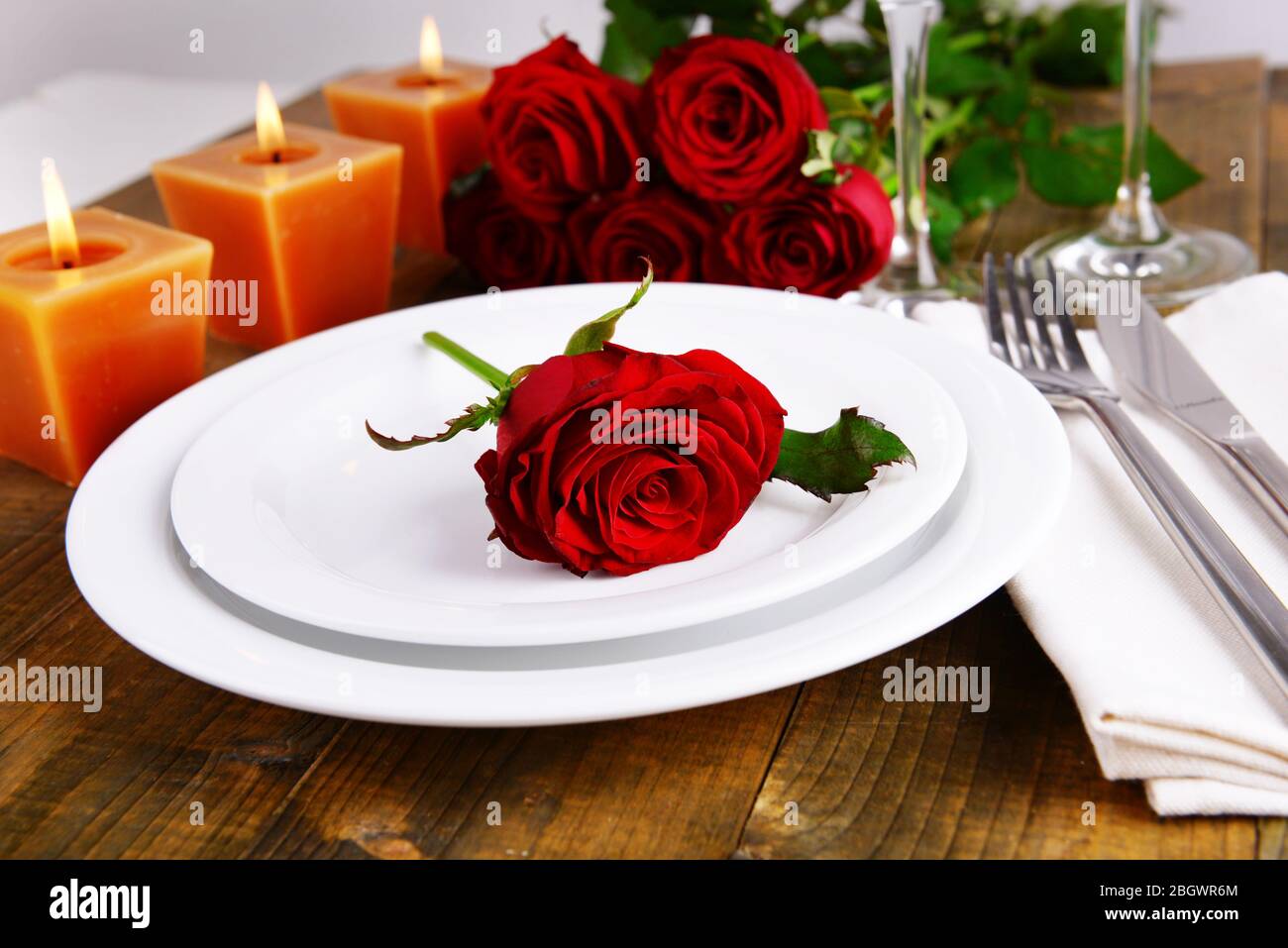 Table setting with red rose on plate Stock Photo - Alamy