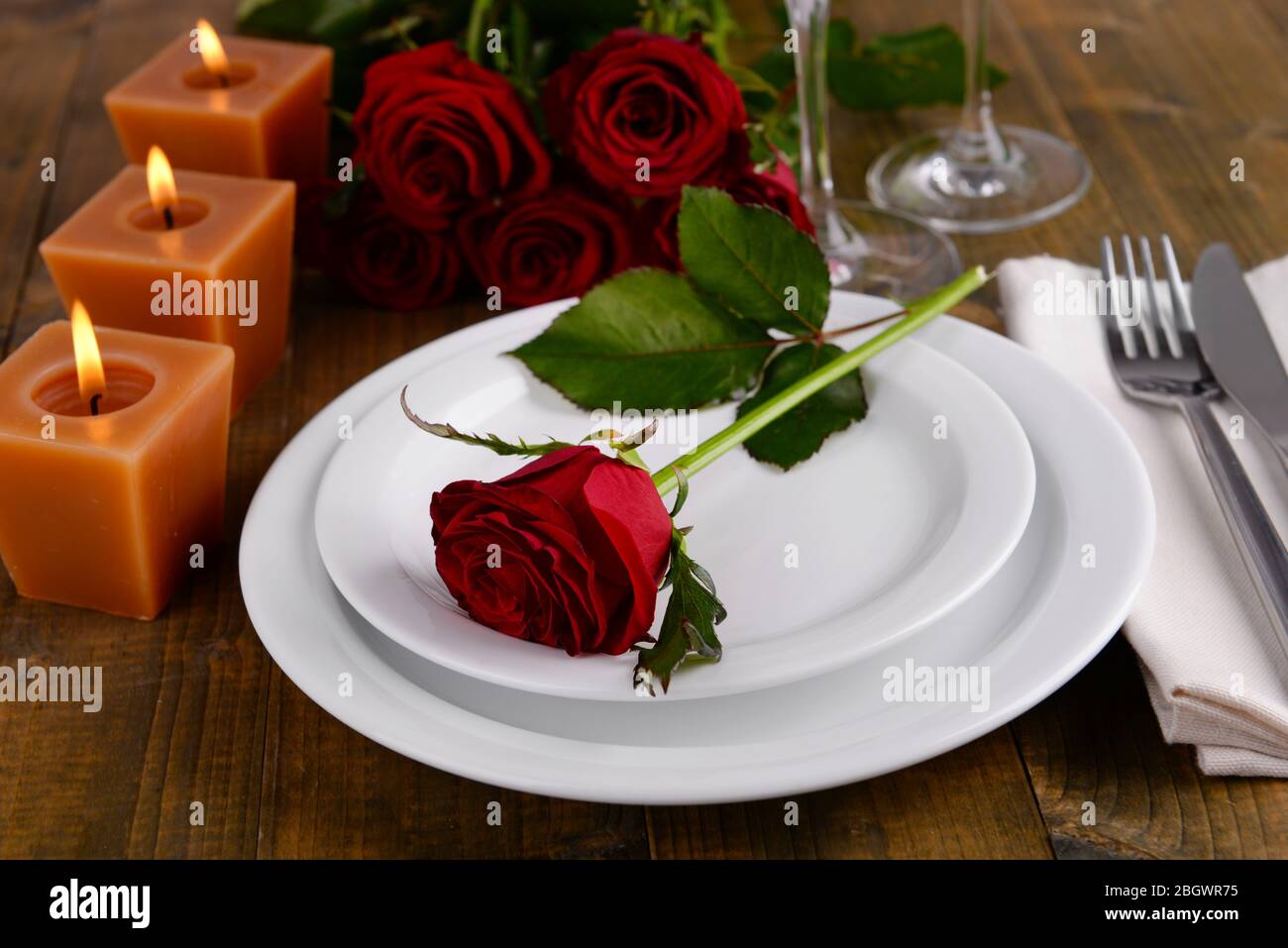 Table setting with red rose on plate Stock Photo - Alamy