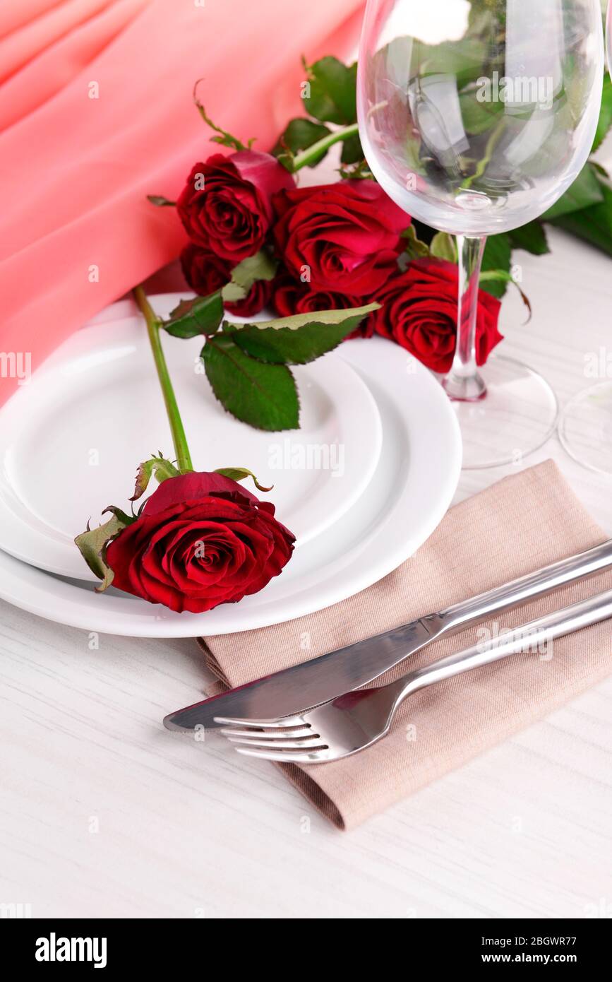 Table setting with red rose on plate Stock Photo - Alamy