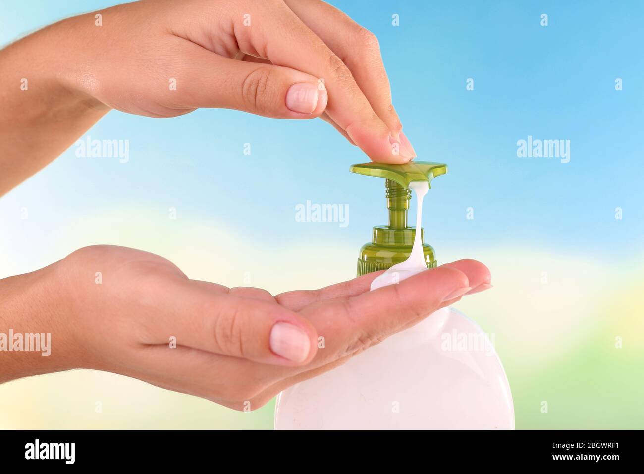 Female hands using liquid soap on light background Stock Photo - Alamy