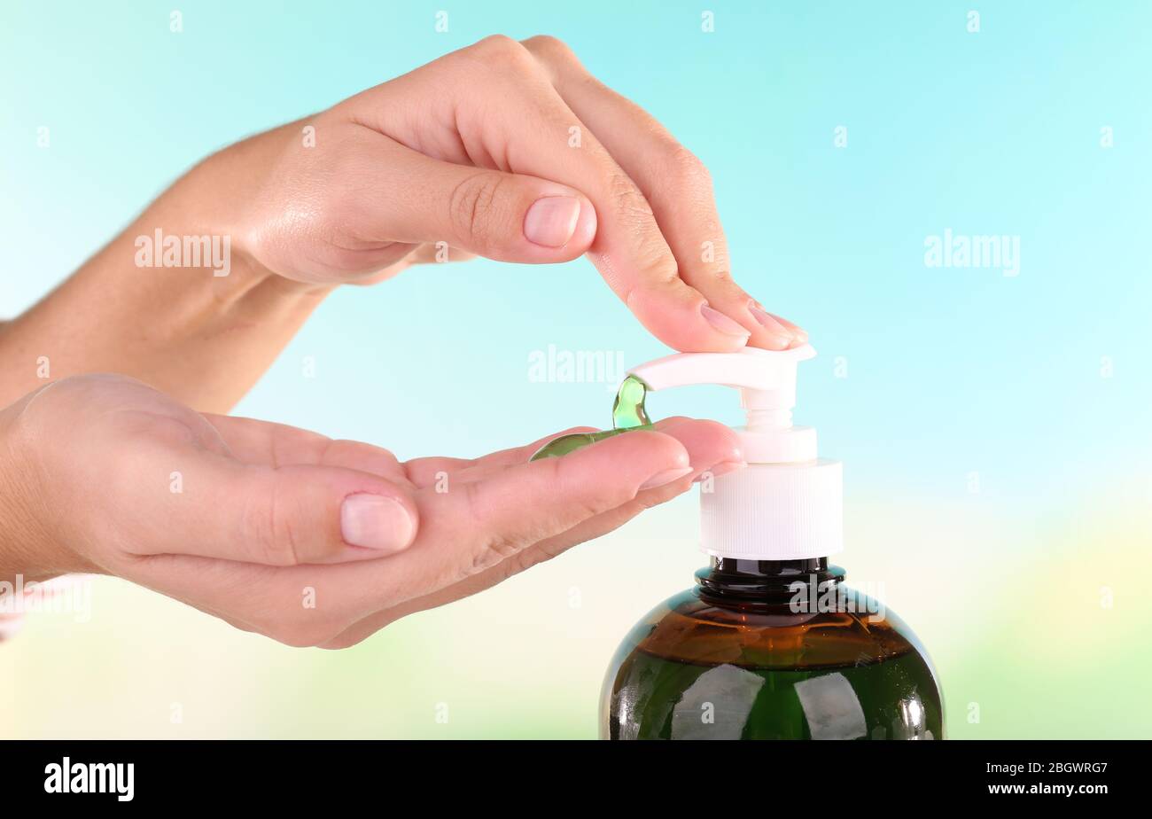 Female hands using liquid soap on light background Stock Photo - Alamy