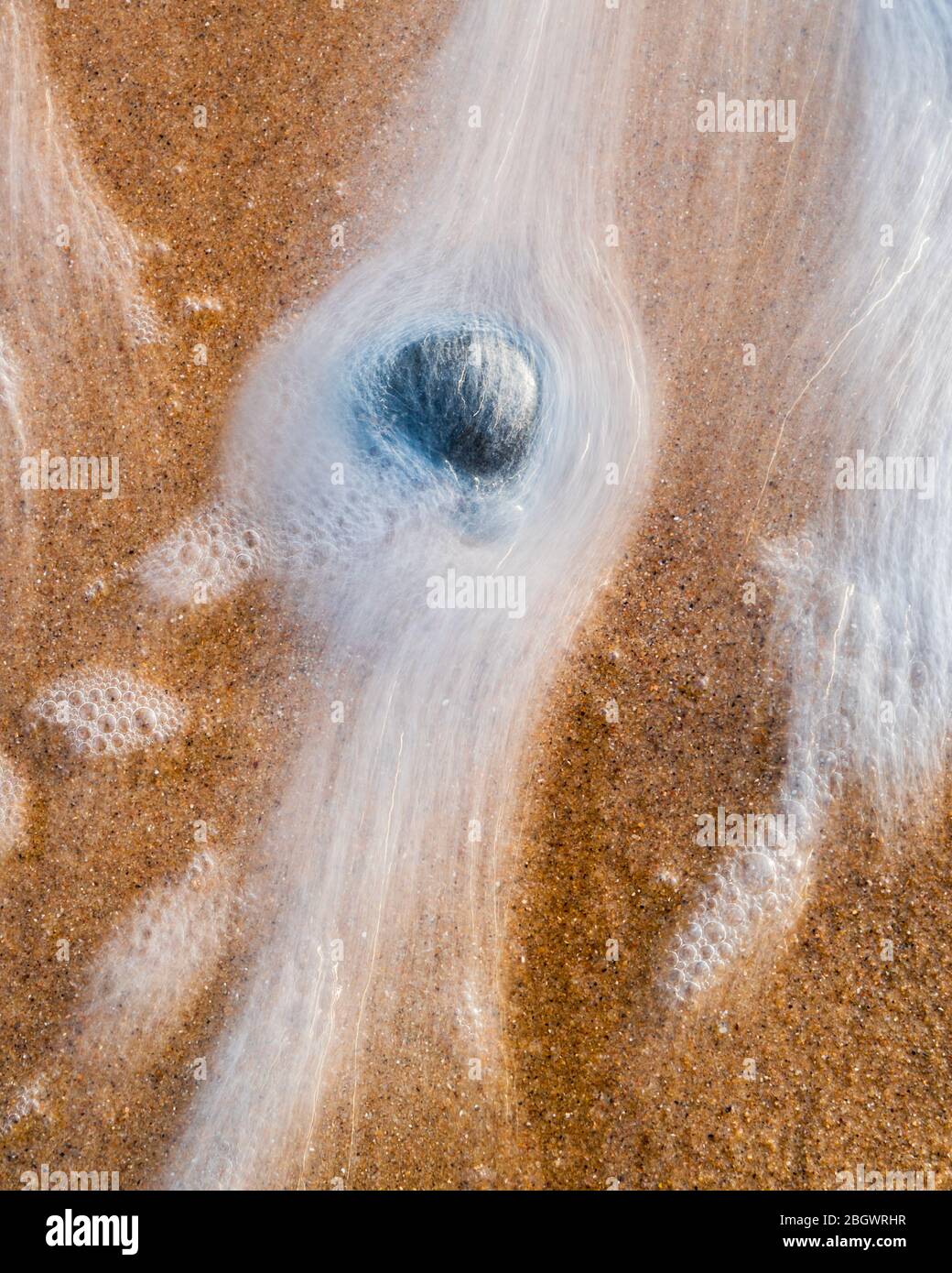 Pebble in beach sand with water movement. Happisburgh, March 2020 Stock ...