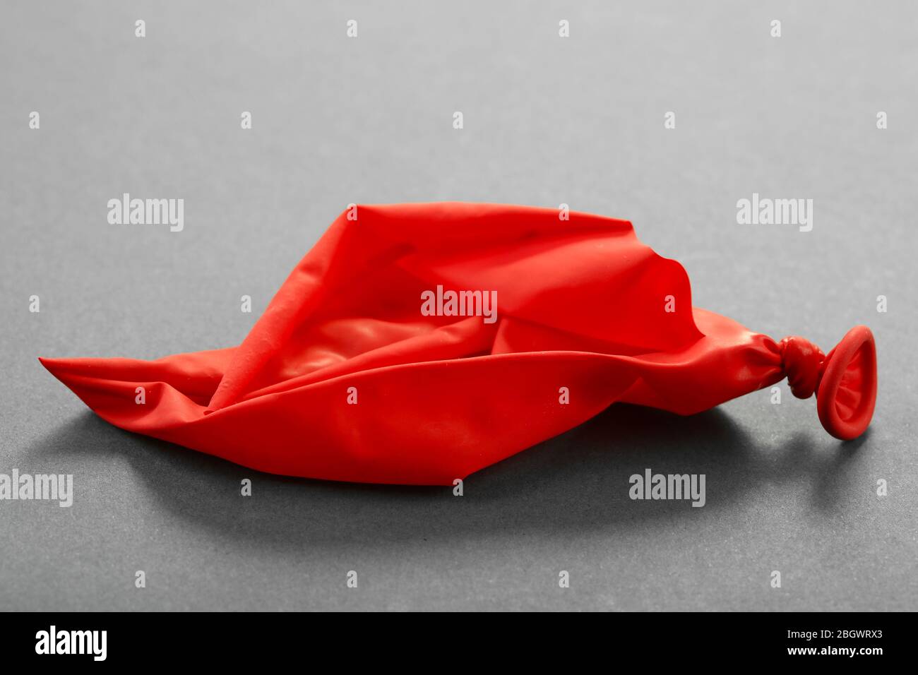 Popped red balloon on paper background Stock Photo - Alamy