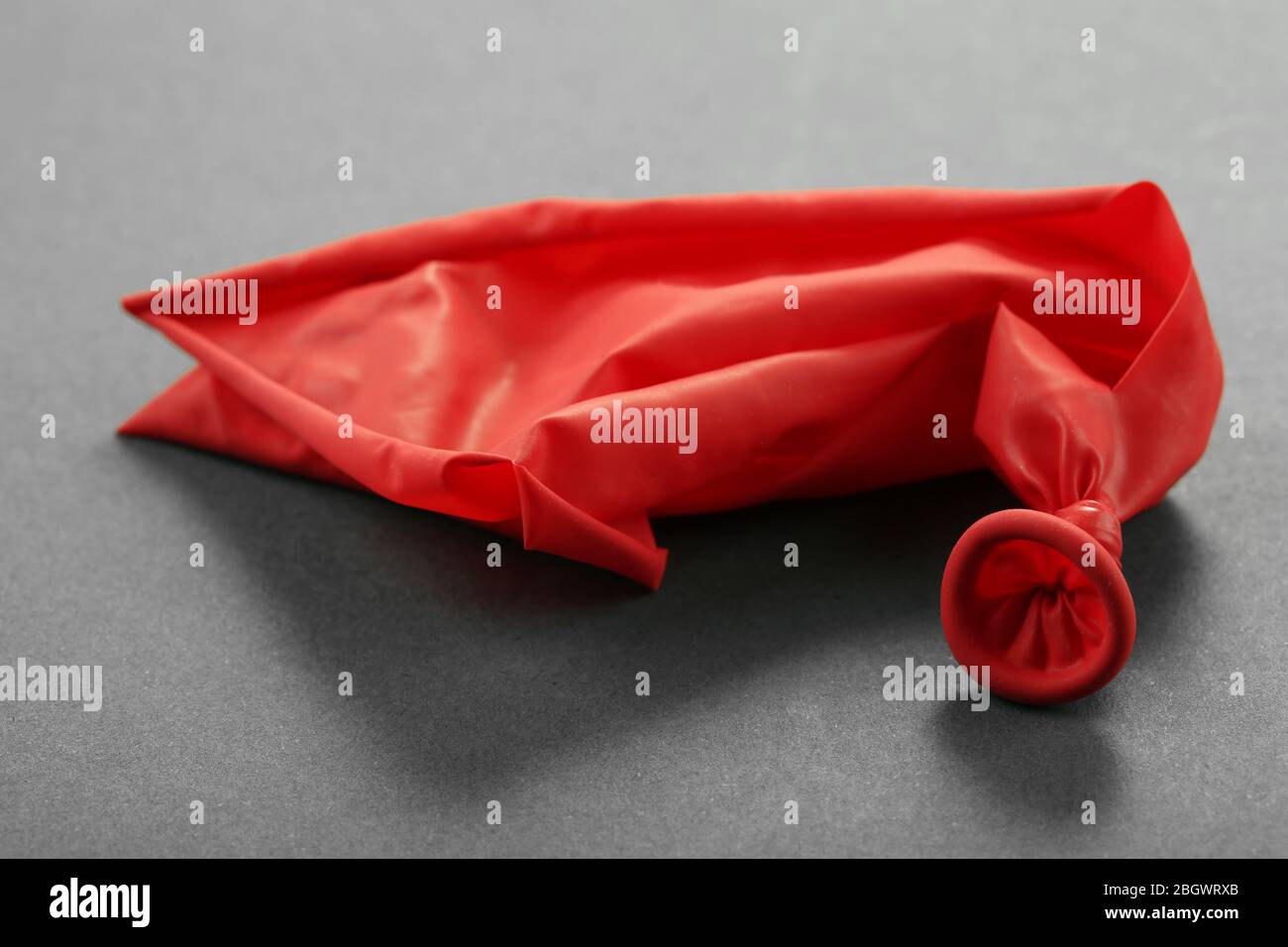 Popped red balloon on paper background Stock Photo - Alamy