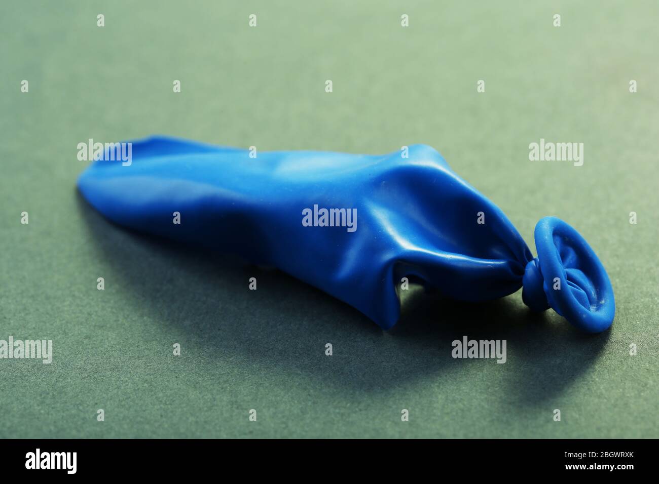 Popped blue balloon on paper background Stock Photo - Alamy