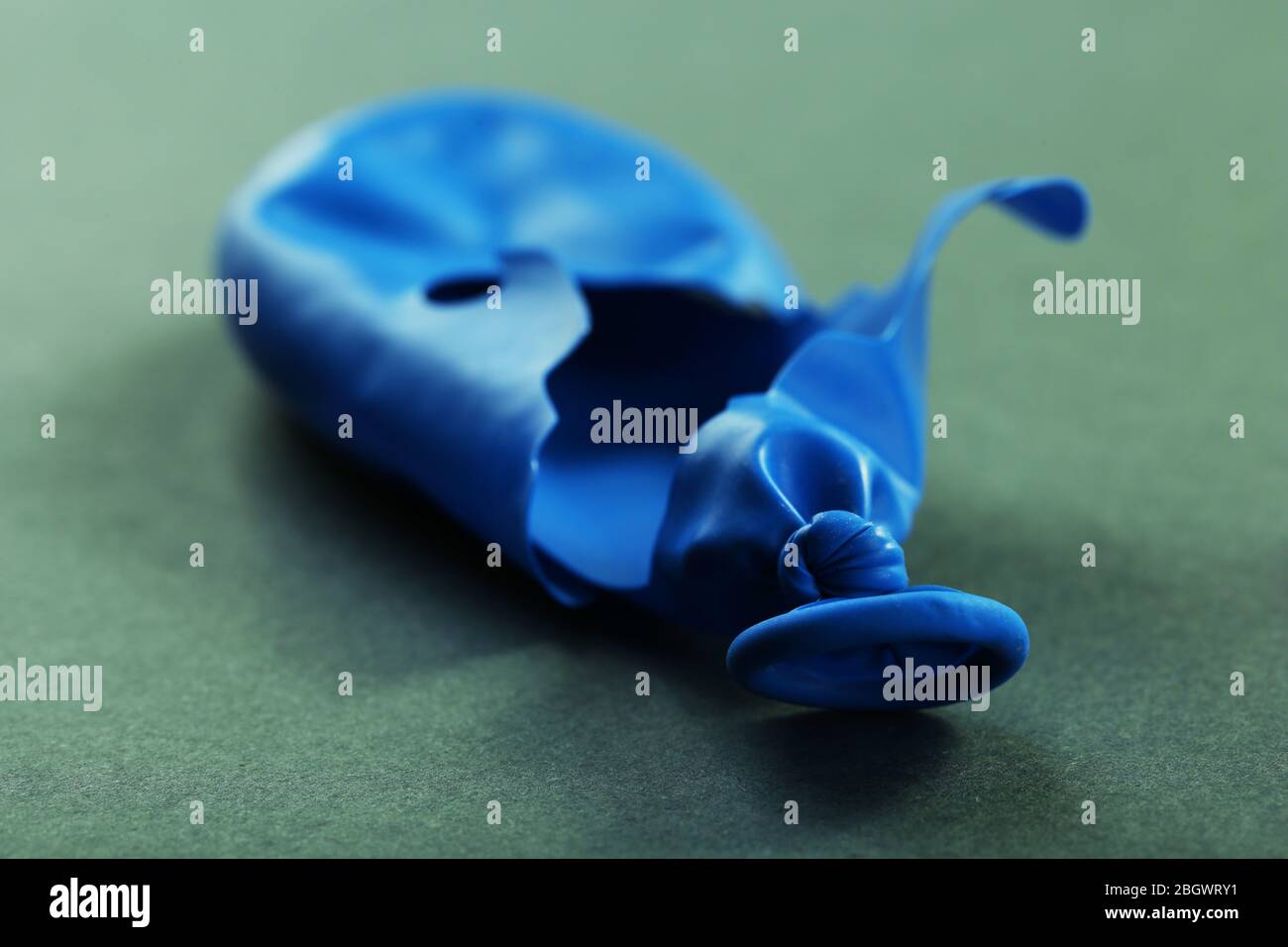 Popped blue balloon on paper background Stock Photo - Alamy
