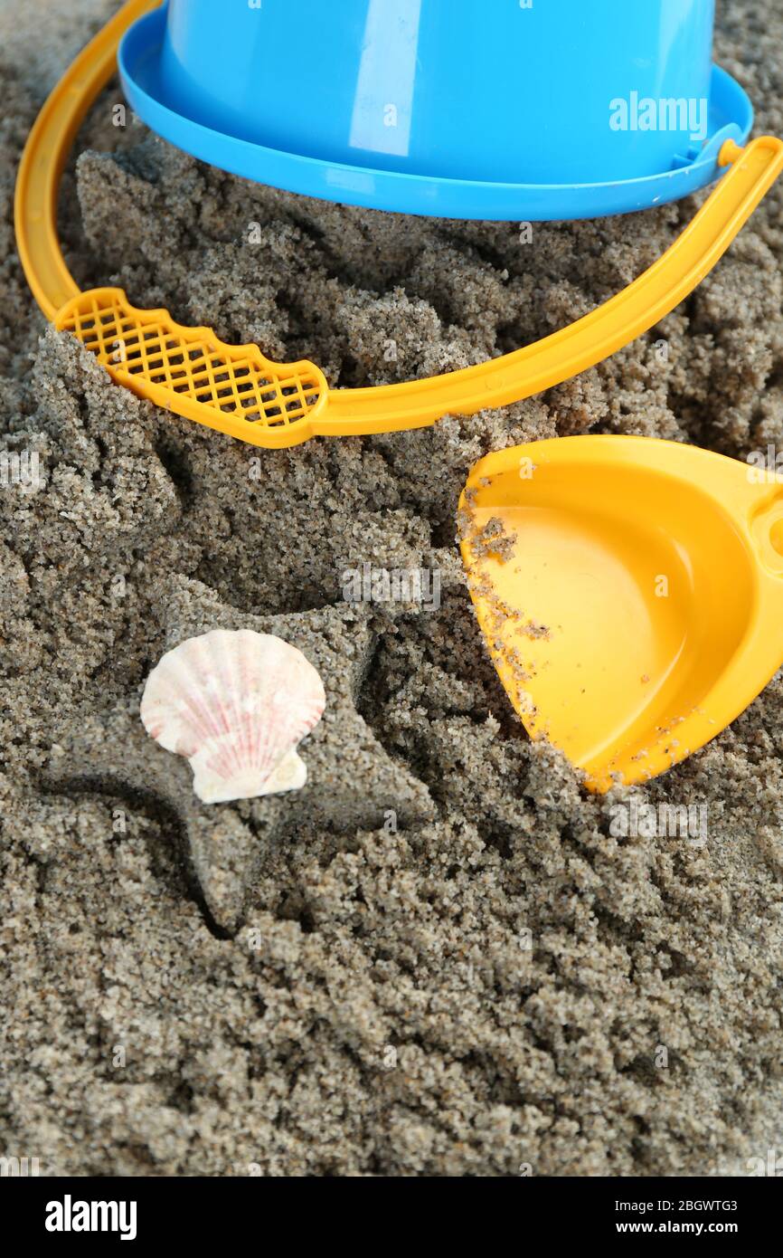Spade and bucket on sandy beach background Stock Photo - Alamy