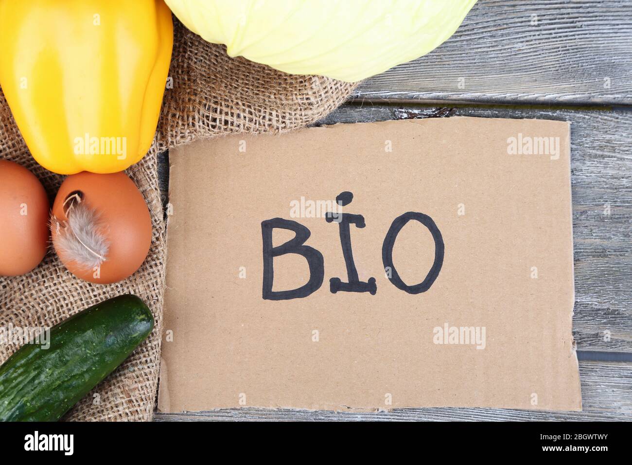 Eggs and vegetables with inscription BIO on card, on wooden background ...