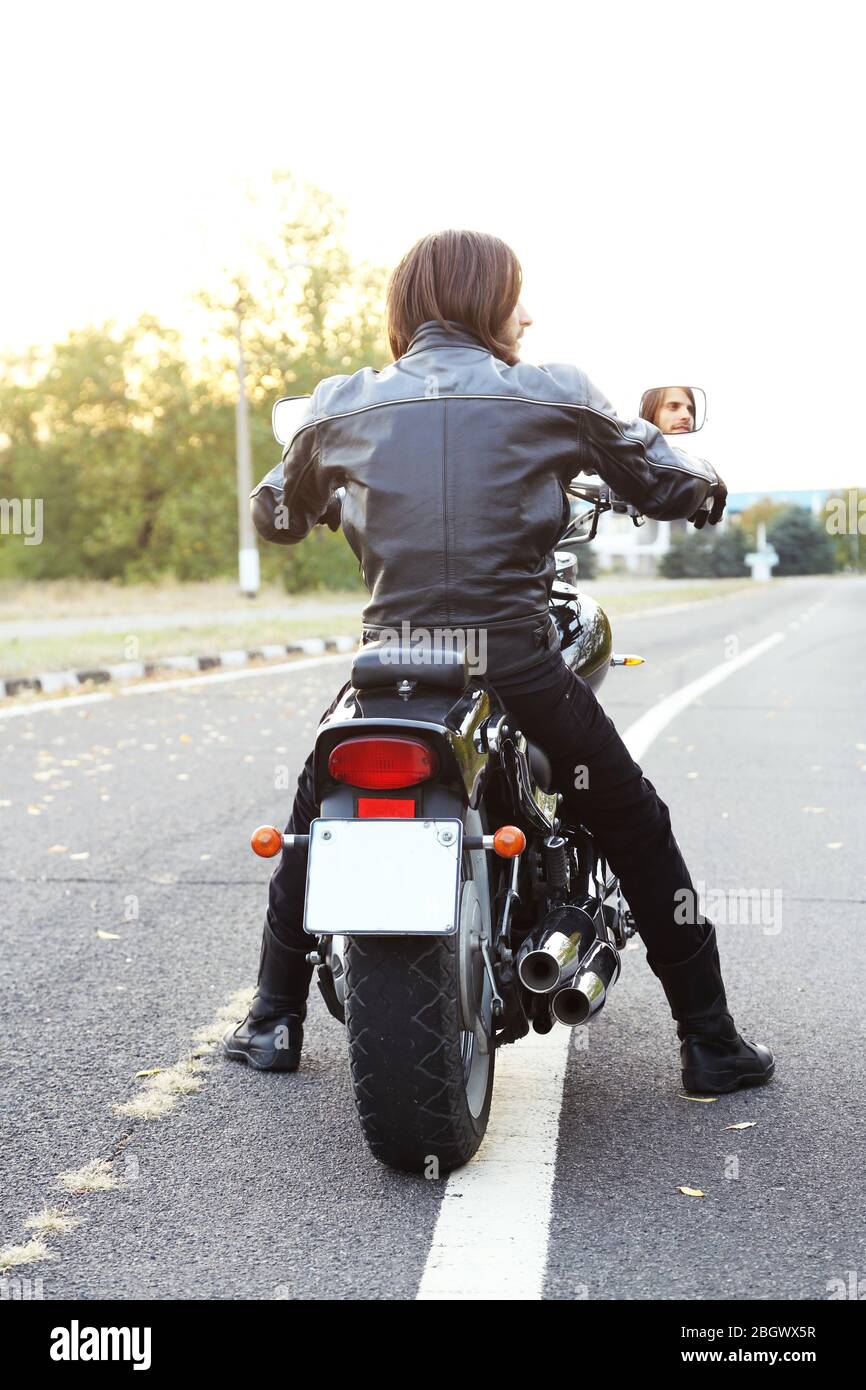Biker man sits on bike Stock Photo - Alamy