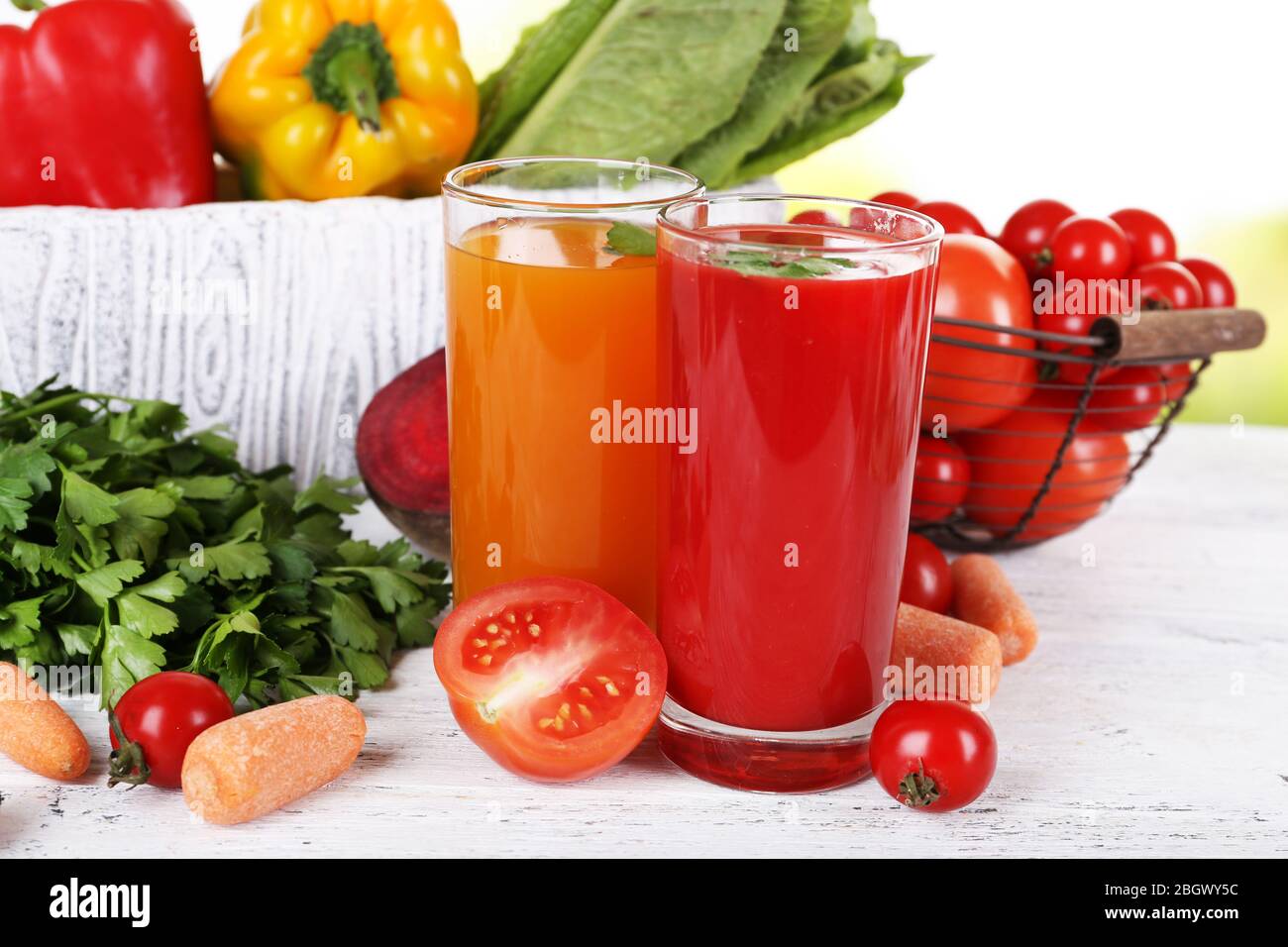 Vegetable juice and fresh vegetables on wooden table on natural ...