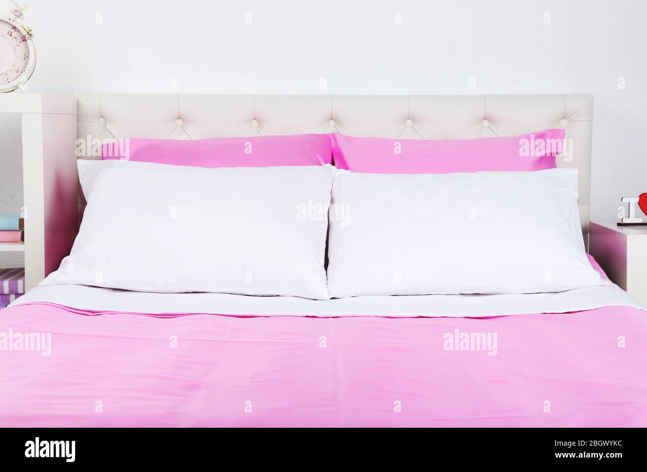 Bed in pink bed linen in room Stock Photo - Alamy