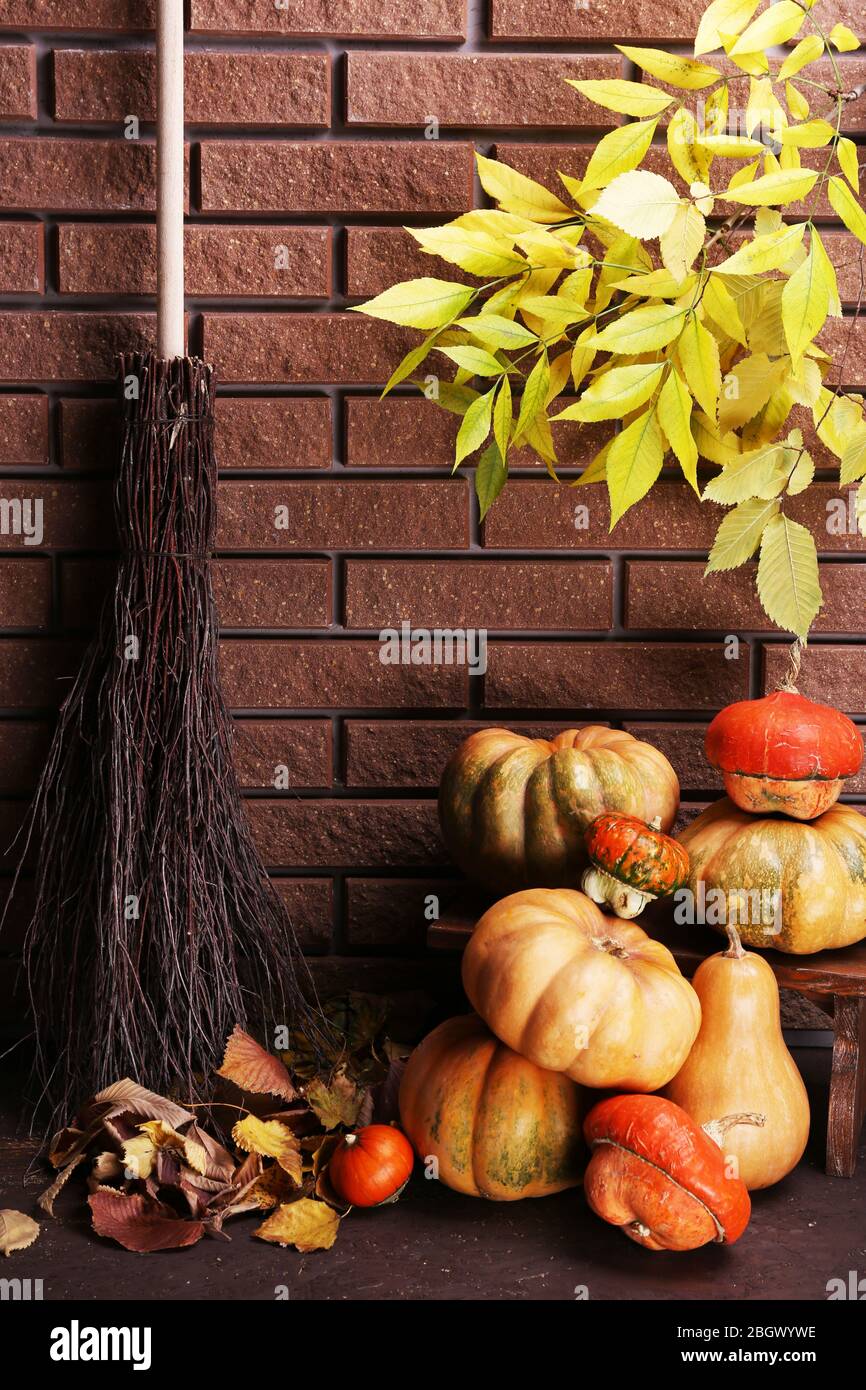 Pumpkins on stool on floor on brick wall background Stock Photo - Alamy