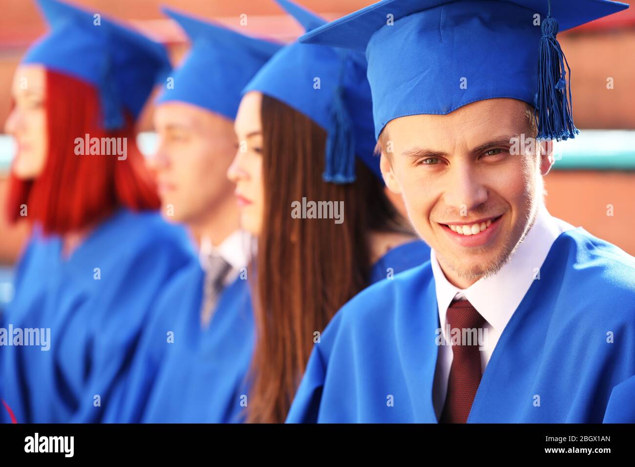 Graduate students wearing graduation hat and gown, outdoors Stock Photo ...