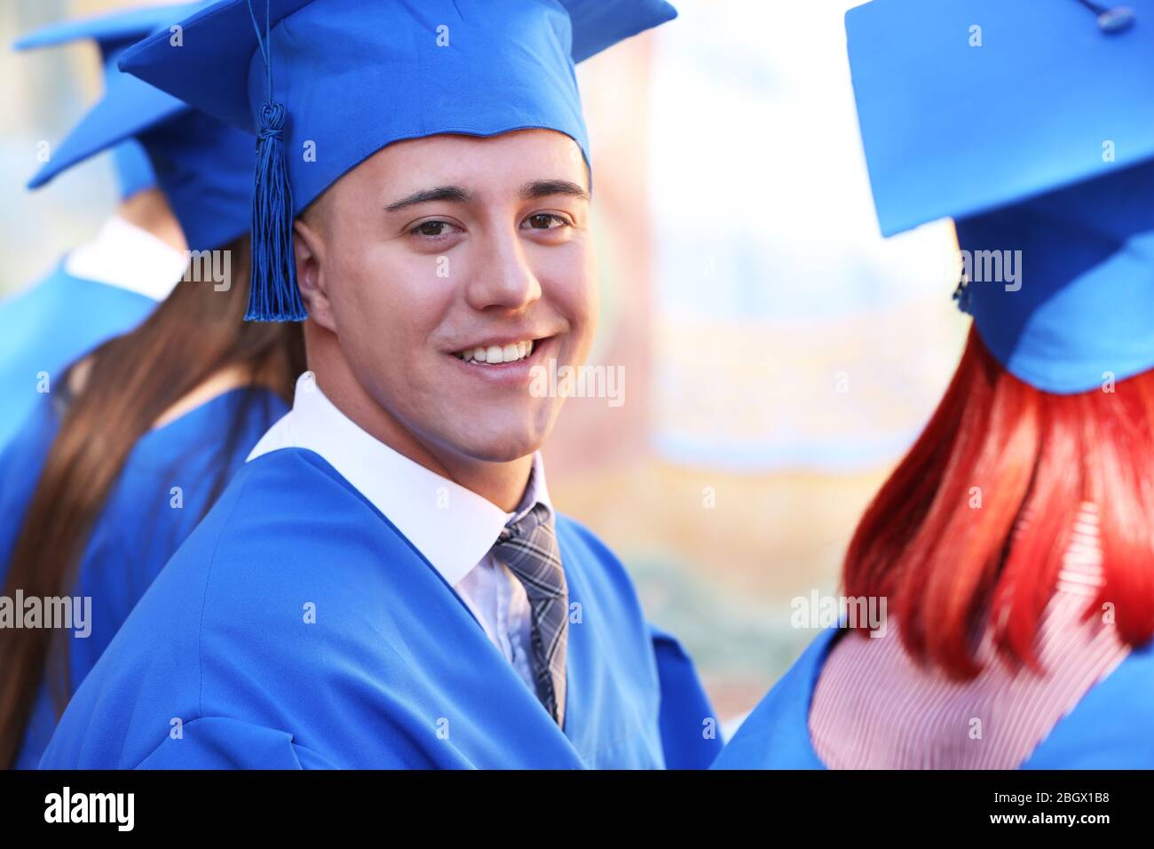 Graduate students wearing graduation hat and gown, outdoors Stock Photo ...