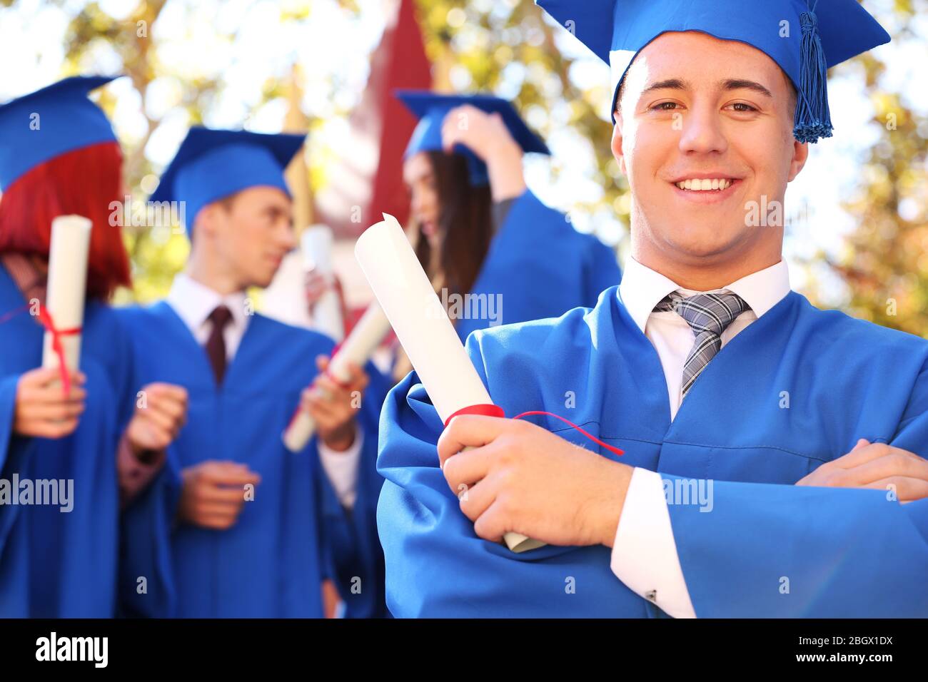 Graduate students wearing graduation hat and gown, outdoors Stock Photo ...