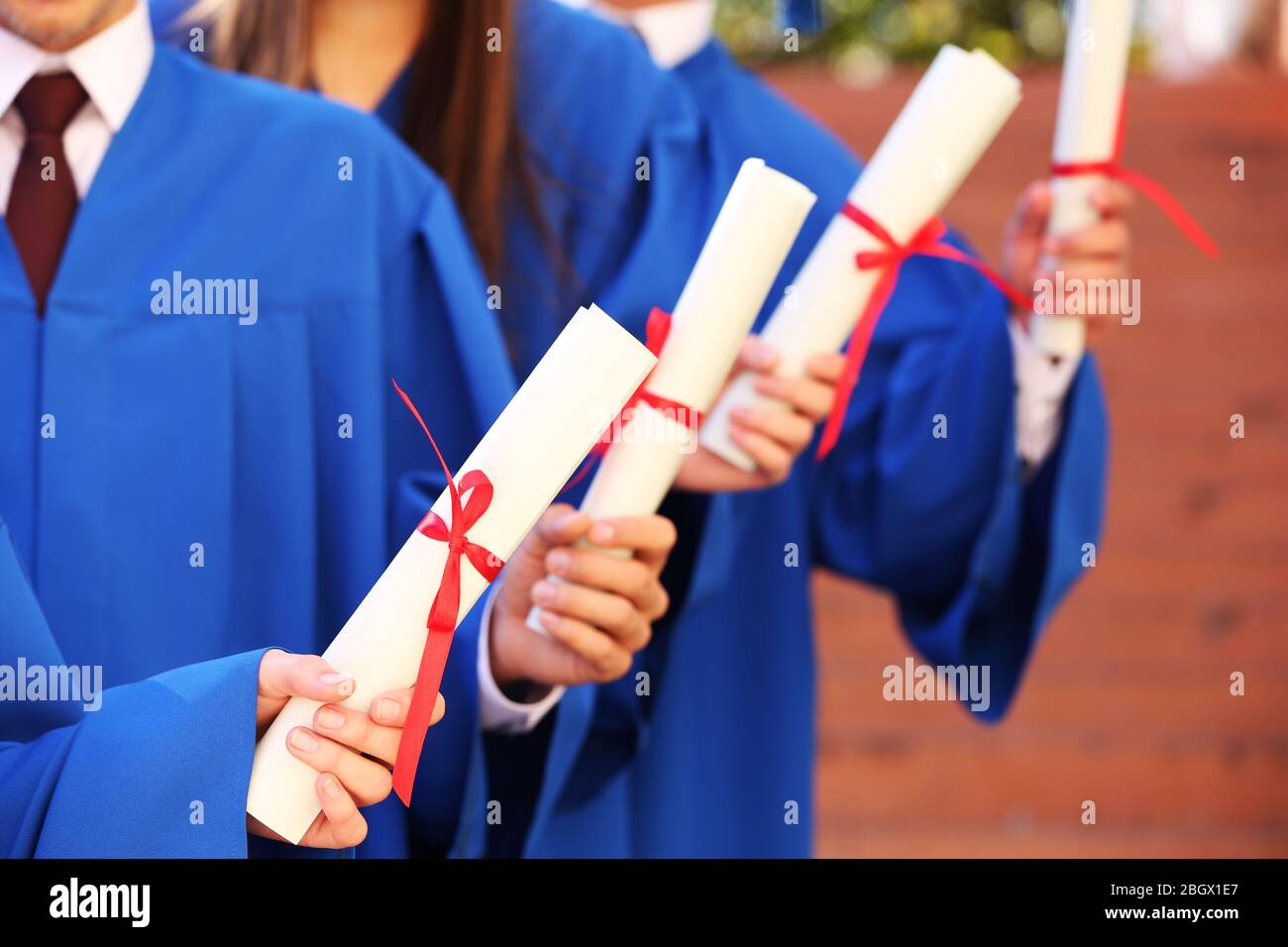 Graduate students with diplomas, outdoors Stock Photo - Alamy
