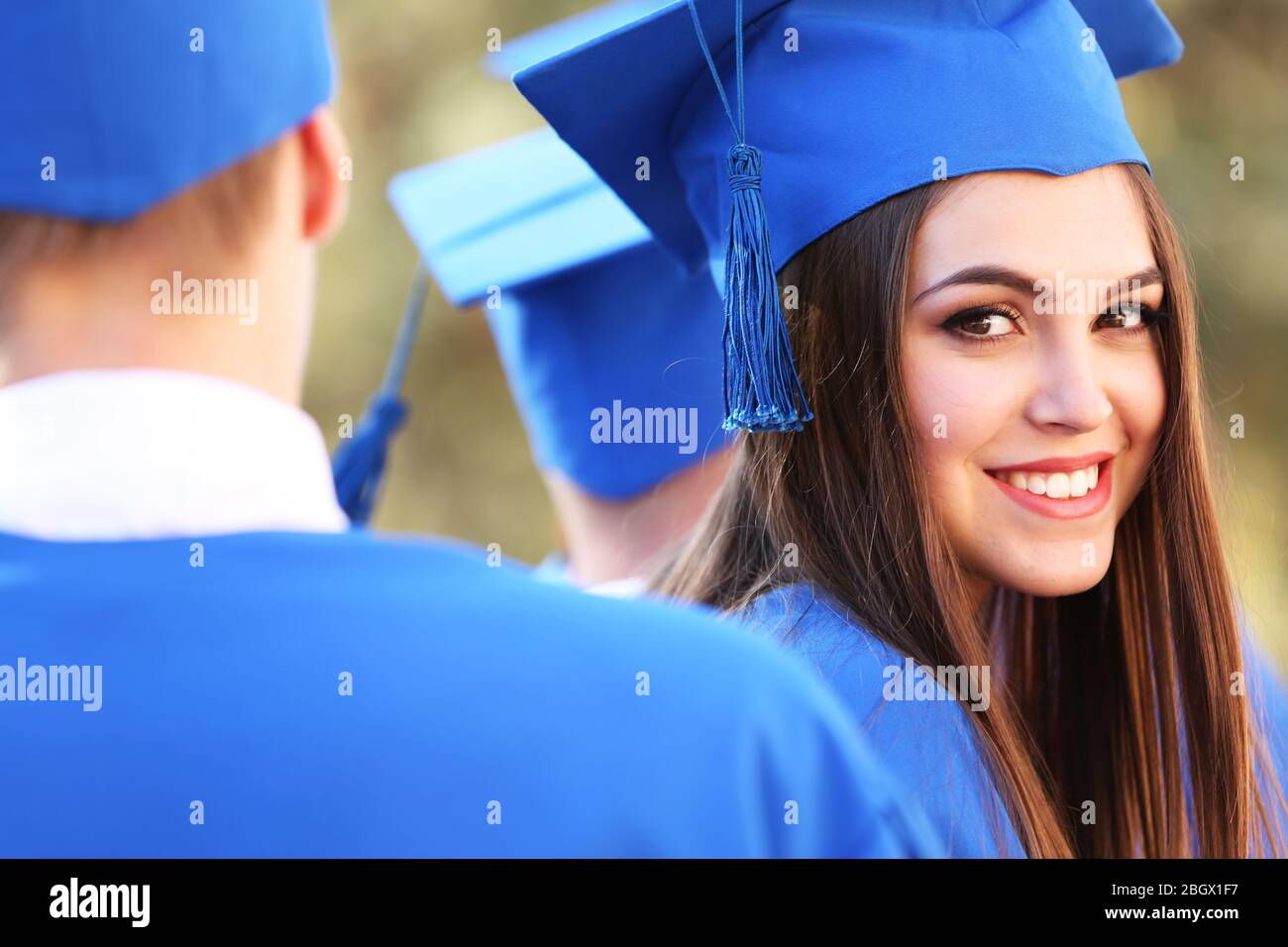 Graduate students wearing graduation hat and gown, outdoors Stock Photo ...