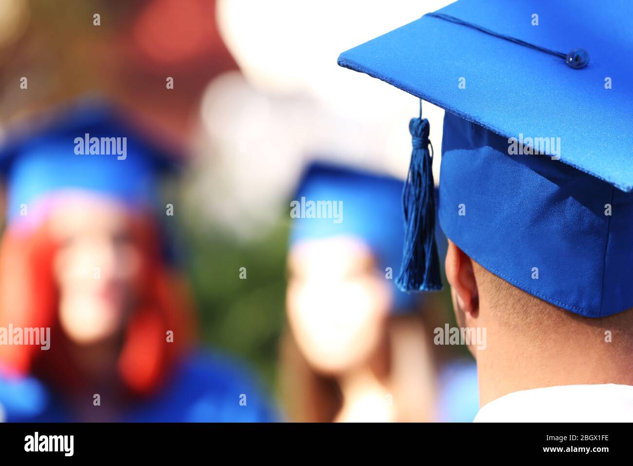Graduate students wearing graduation hat and gown, outdoors Stock Photo ...