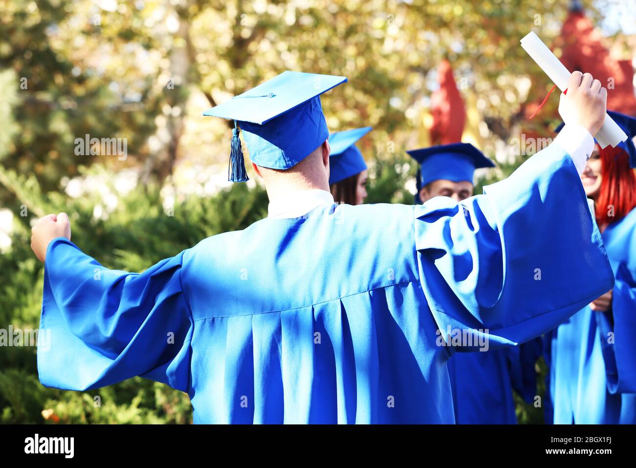 Graduate students wearing graduation hat and gown, outdoors Stock Photo ...
