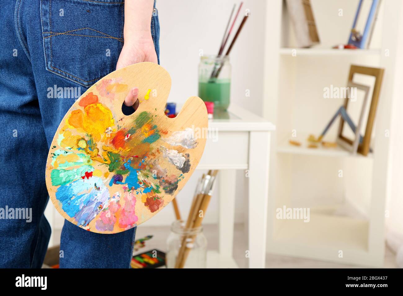 Artist holding palette with paints in art studio Stock Photo - Alamy