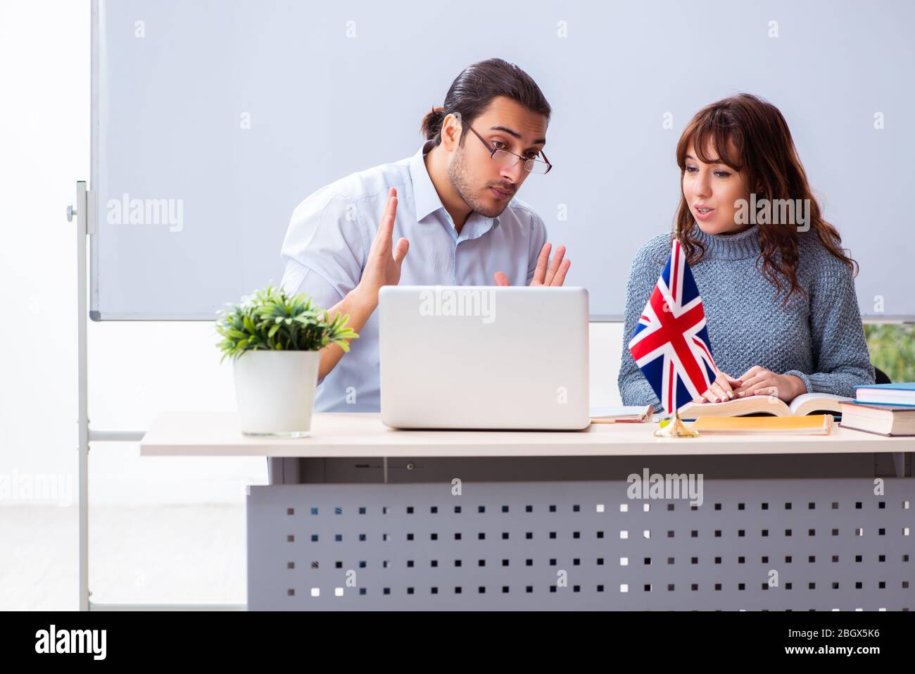 Young student and male english teacher in the classroom Stock Photo - Alamy