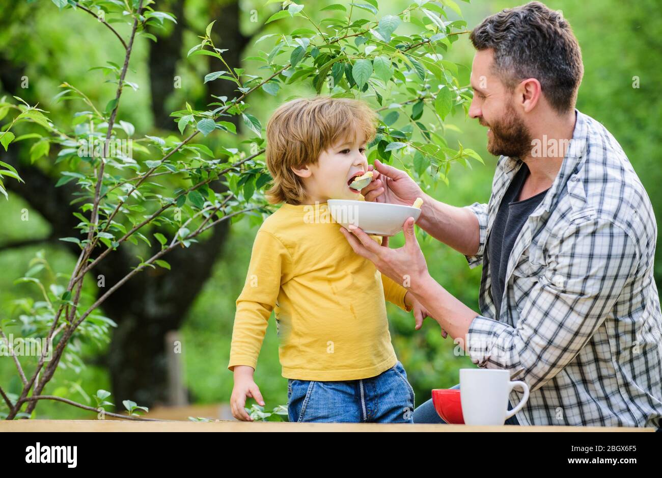 family and parenting. happy fathers day. Little boy with dad eat cereal ...