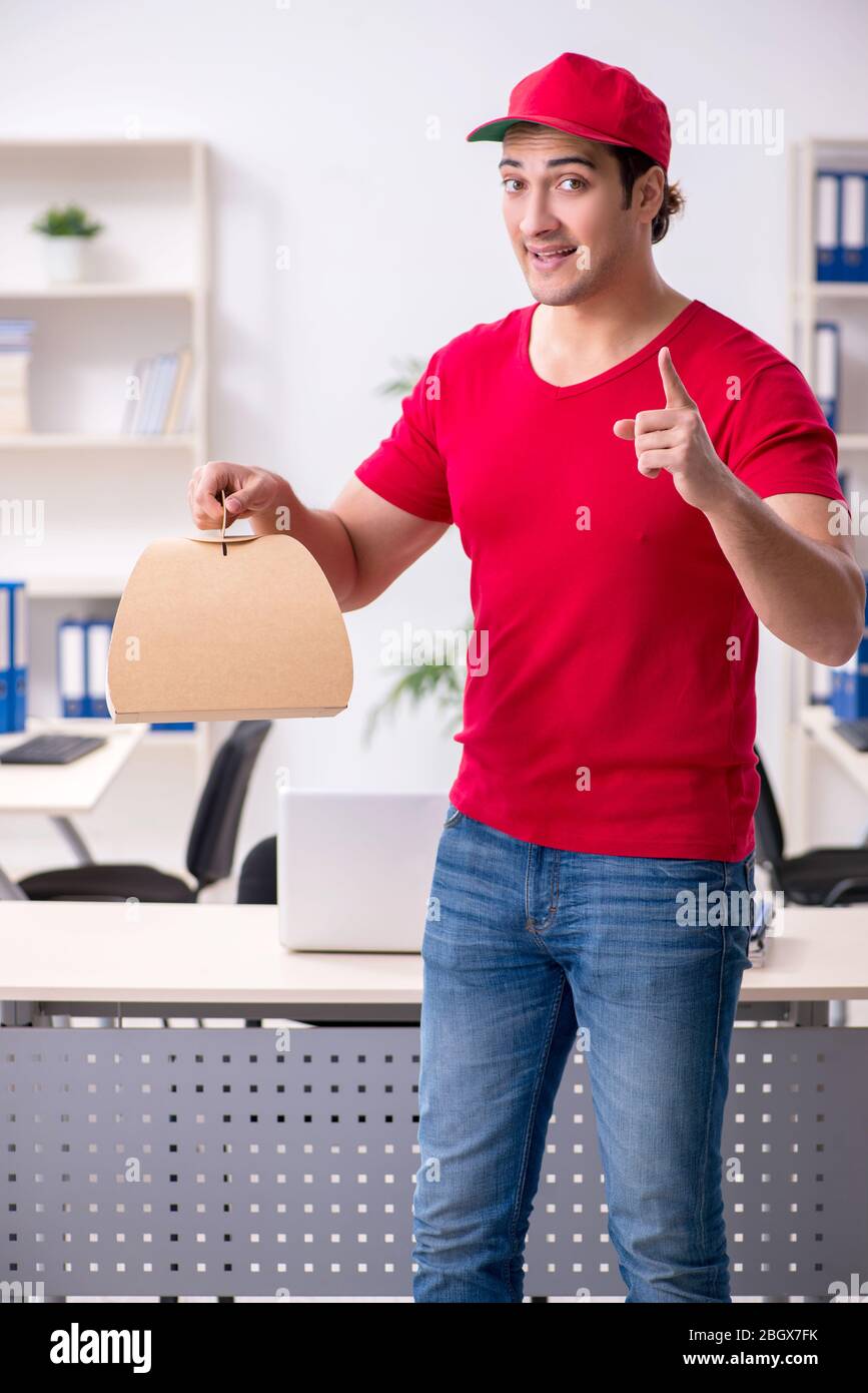 Young courier delivering cake to the office Stock Photo - Alamy