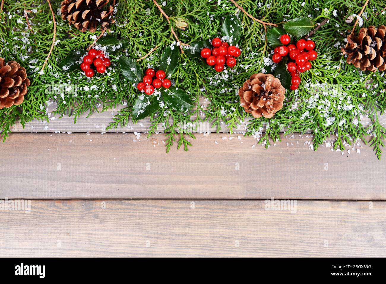Beautiful Christmas border from fir and mistletoe on wooden background ...