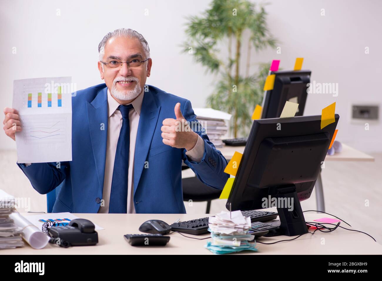 Old sales analyst working in the office Stock Photo - Alamy