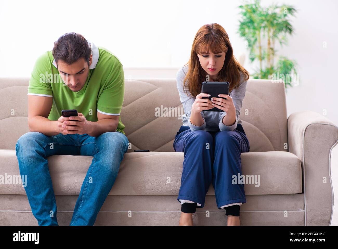 Young couple in gadget dependency disorder Stock Photo - Alamy