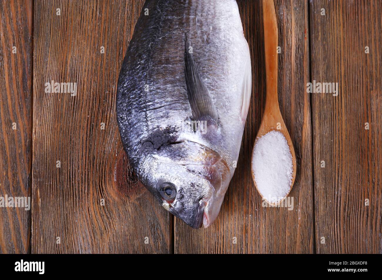 Fresh fish and salt in spoon on wooden background Stock Photo - Alamy