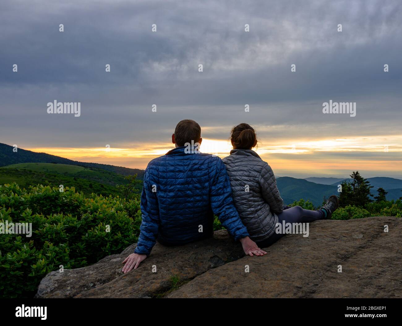 Couple Looks Out Over Sunset Falling on Blue Ridge mountains Stock ...