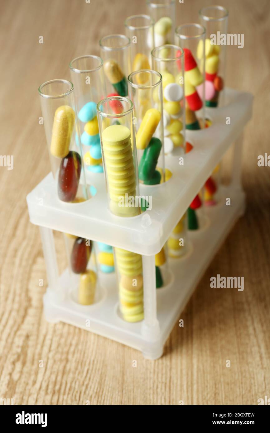 Different color drugs in test tubes, on wooden table background Stock ...