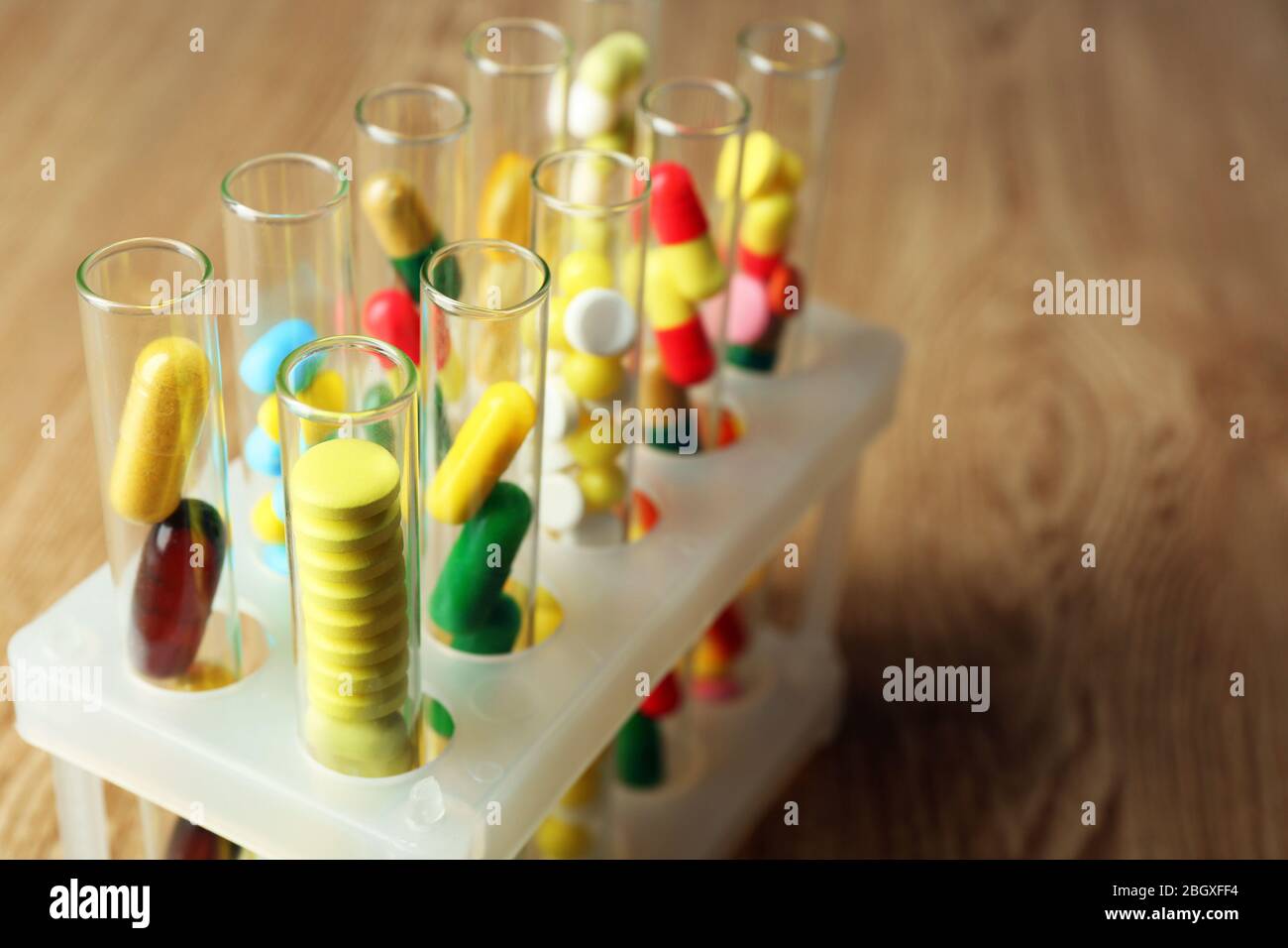 Different color drugs in test tubes, on wooden table background Stock ...