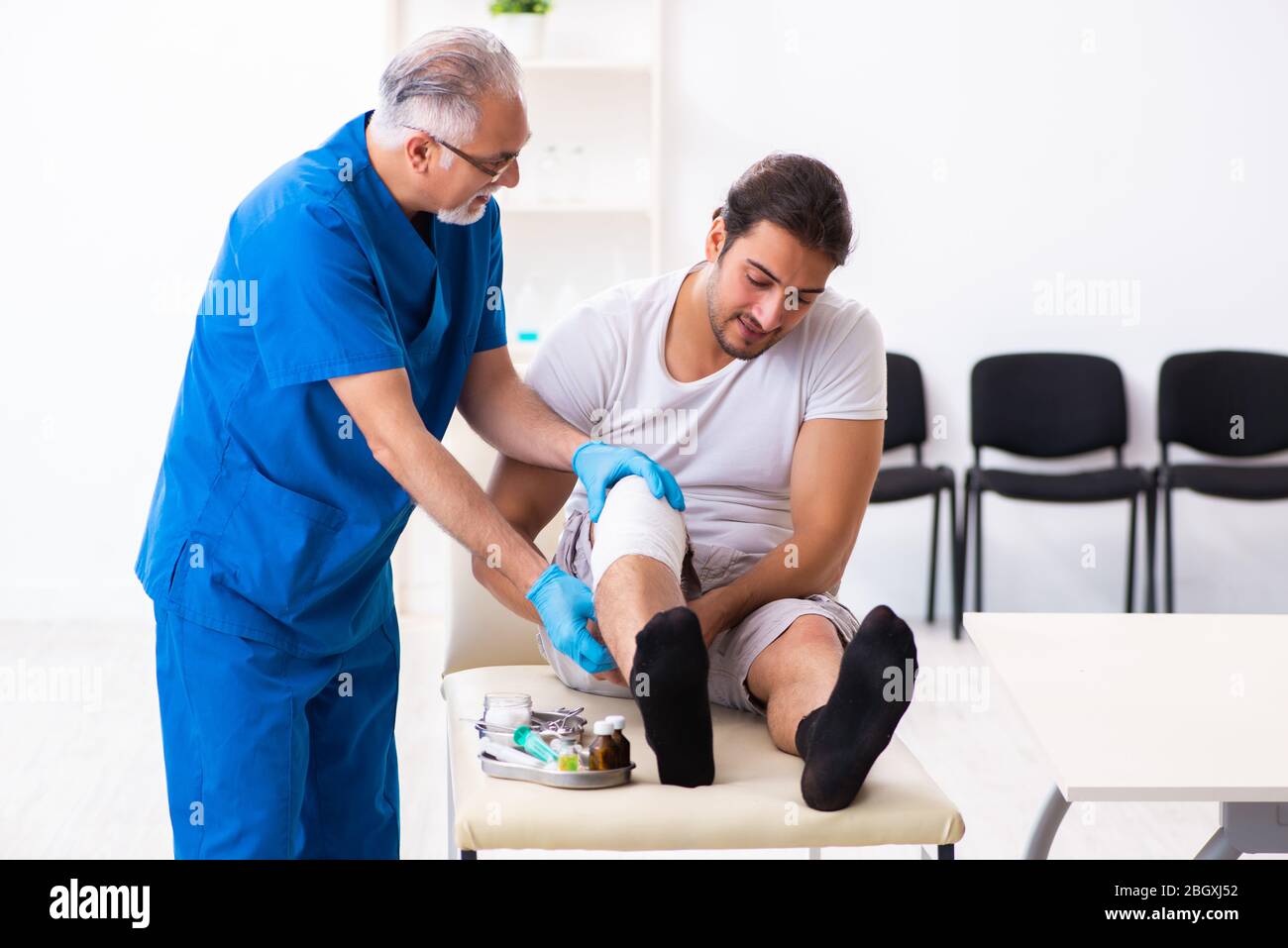 Leg injured man visiting doctor in first aid concept Stock Photo - Alamy