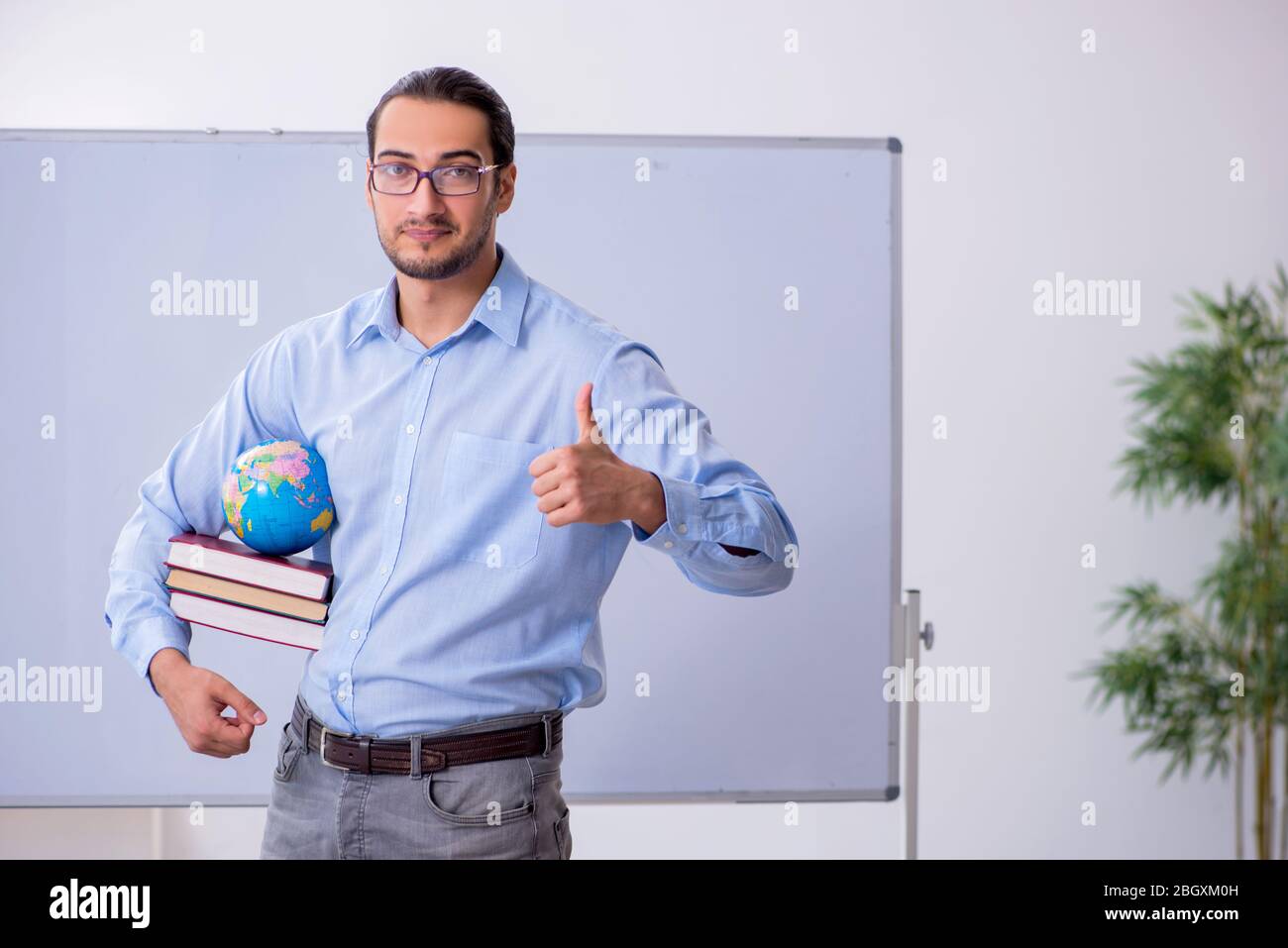 Young geography teacher in front of whiteboard Stock Photo - Alamy