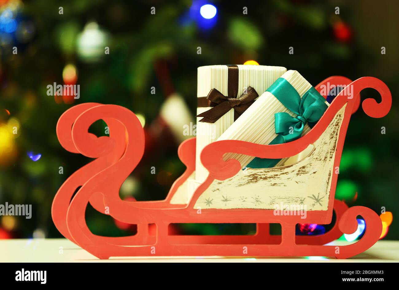 Decorative sledge with gifts on Christmas tree lights background Stock ...