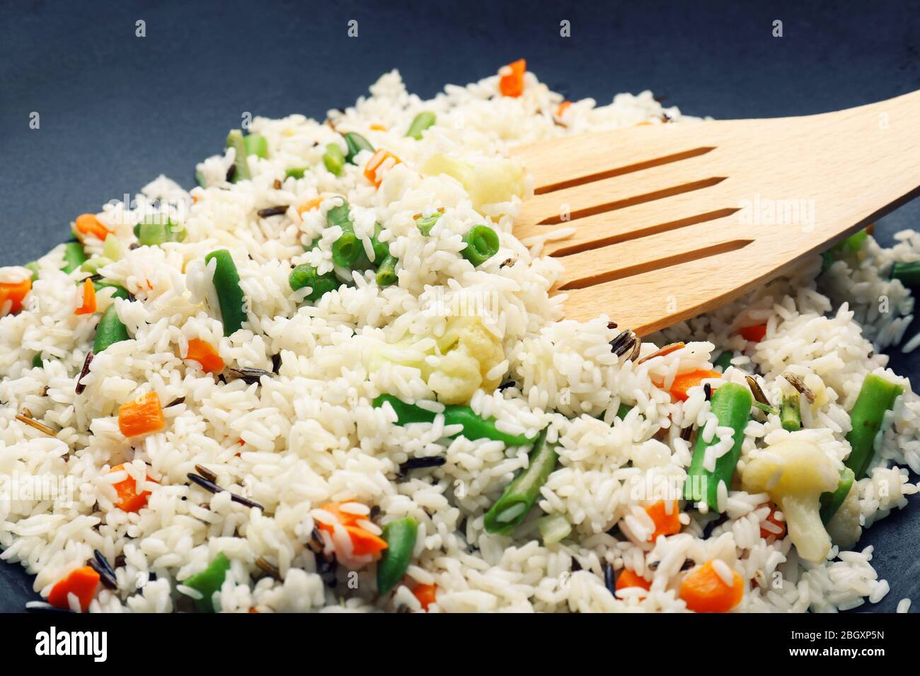 Tasty rice preparing in wok, close-up Stock Photo - Alamy