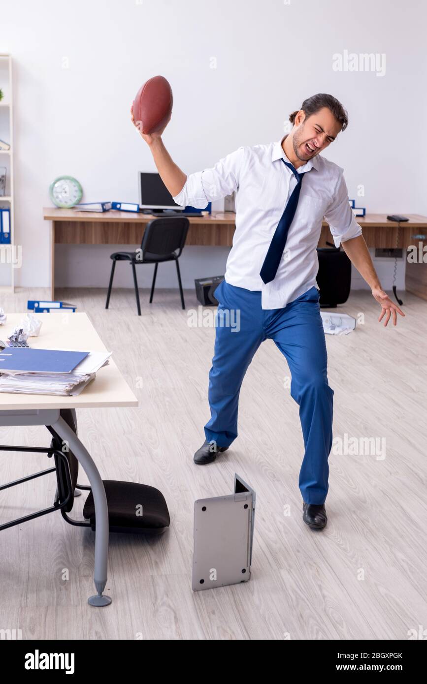 Young employee throwing rugby ball in the office Stock Photo - Alamy