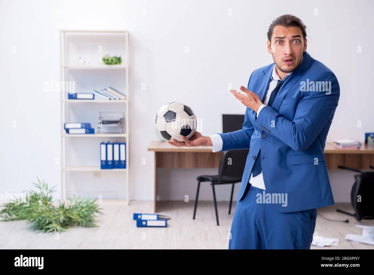 Young employee playing football in the office Stock Photo - Alamy