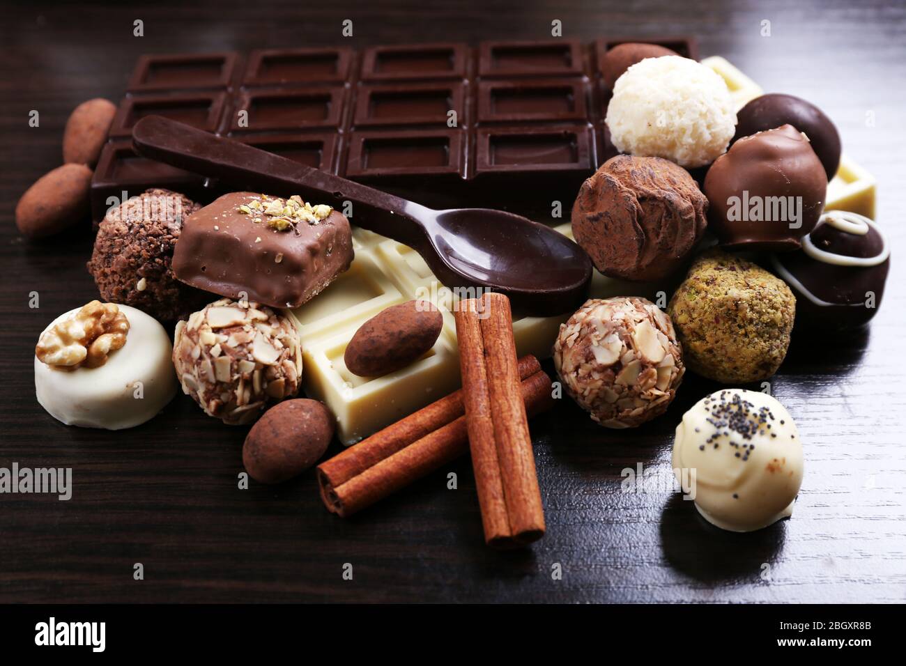 Bars of white and bitter chocolates with candies and sweet spoon on the ...
