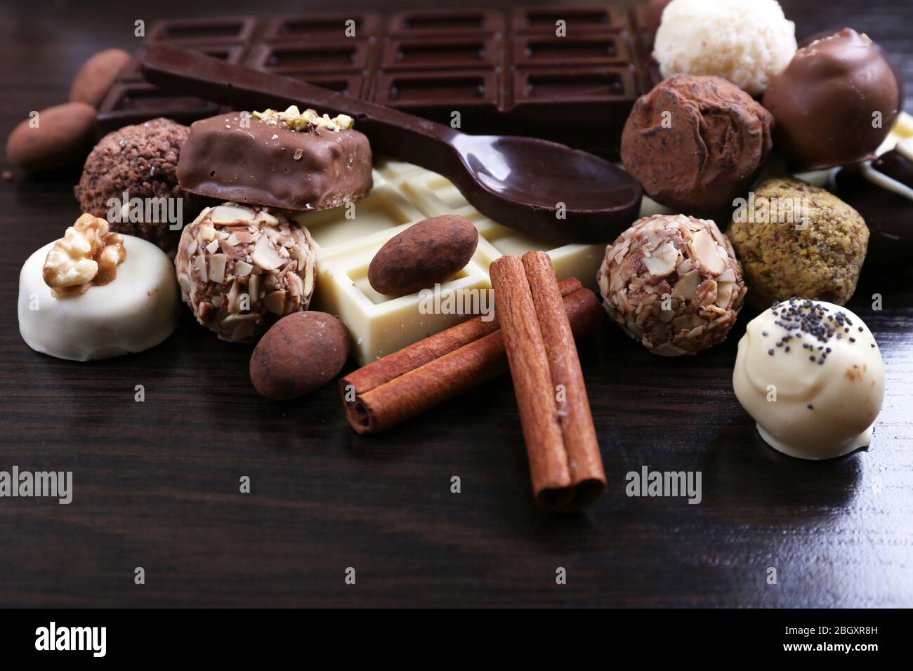 Bars of white and bitter chocolates with candies and sweet spoon on the ...