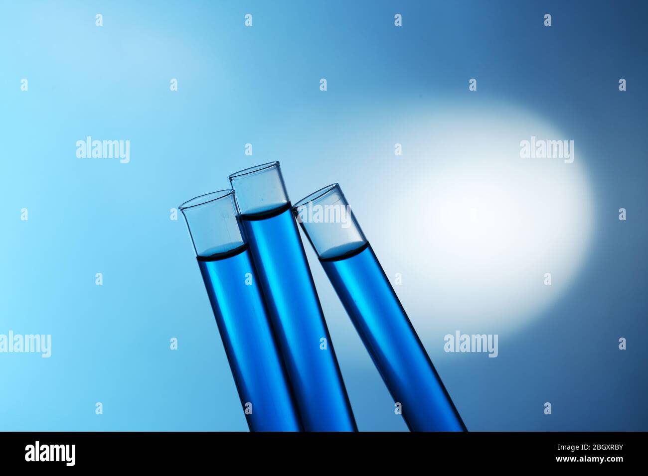 Inclined test-tubes with blue water on the shadows background Stock ...